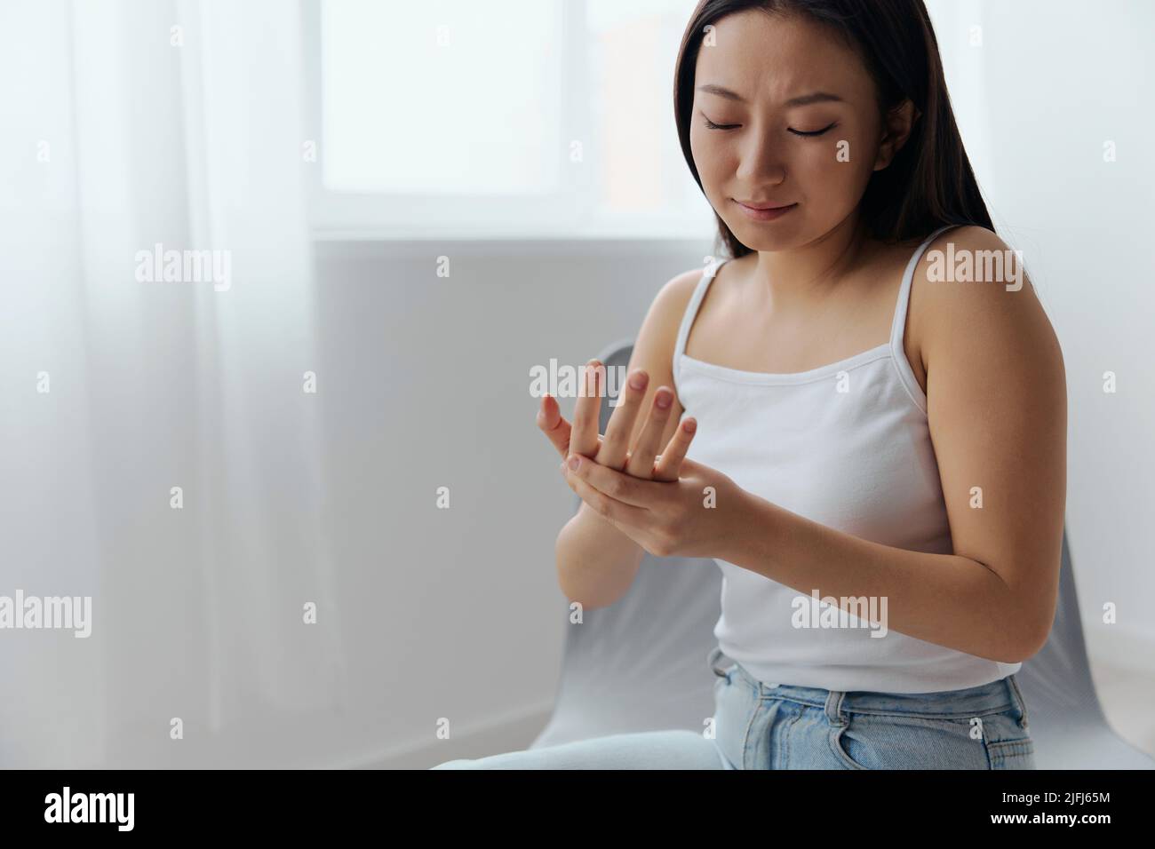 Broken hand Cramp. Upset suffering tanned beautiful young Asian woman ...