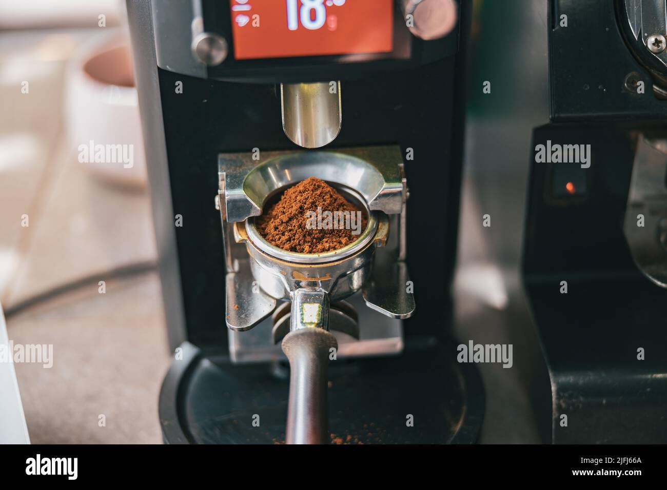 Process of grinding coffee beans pouring into a portafilter using ...