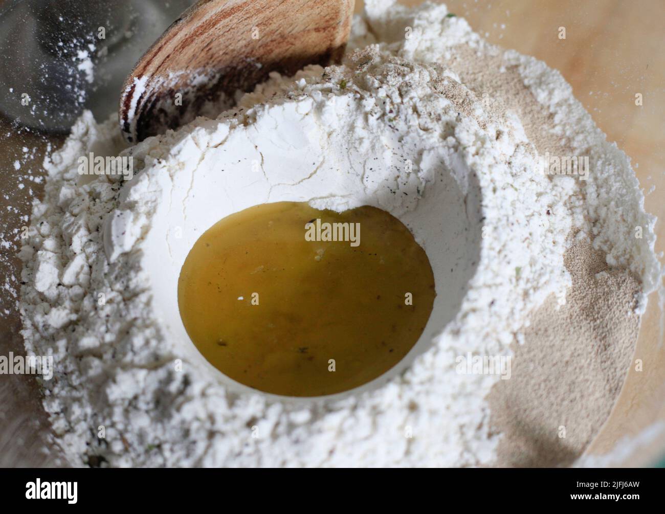 Breadmaking flour in glass bowl with olive oil in circular well Stock ...