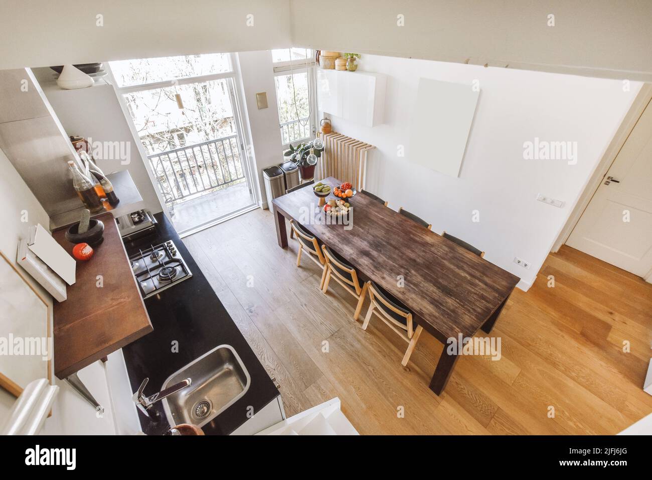 Top view of bright kitchen and dining room interior with balcony doors ...