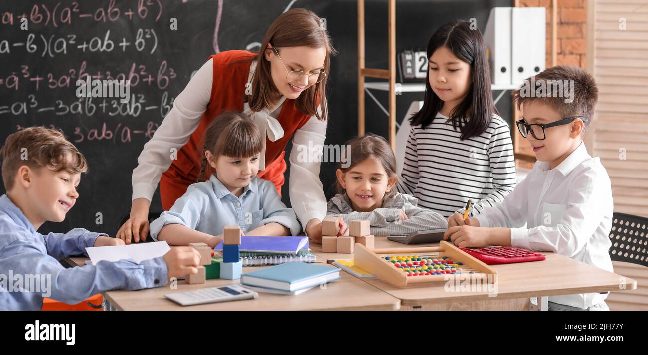 Children with maths teacher during lesson in classroom Stock Photo - Alamy