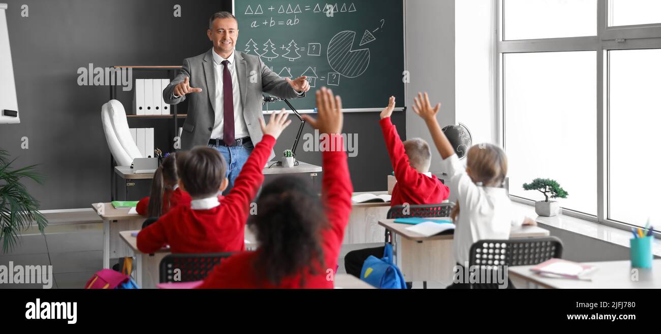 Male teacher conducting lesson in classroom Stock Photo - Alamy
