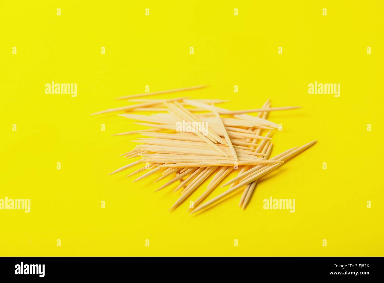 Wooden toothpicks on yellow background Stock Photo - Alamy