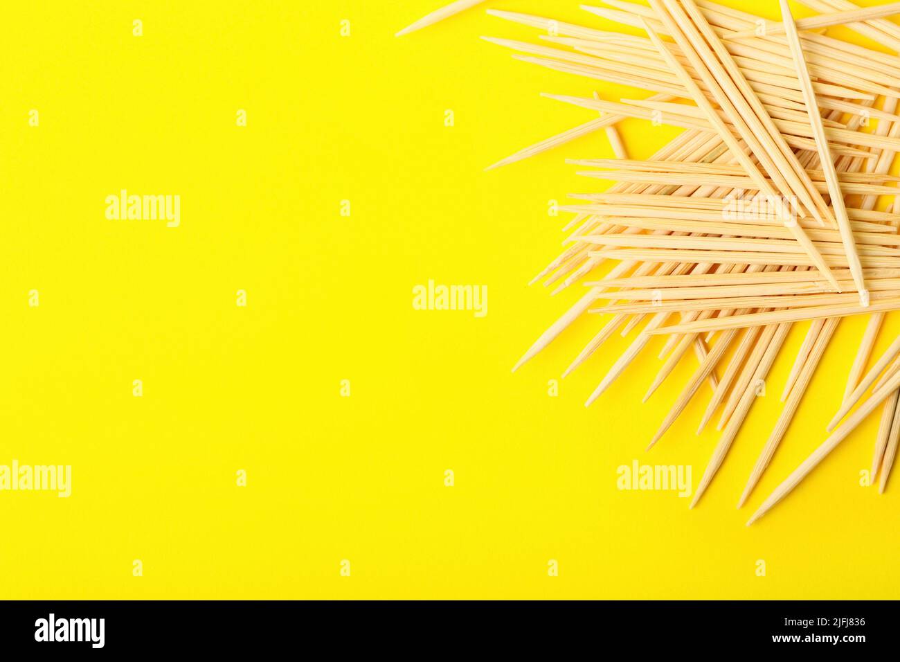 Wooden toothpicks on yellow background Stock Photo - Alamy