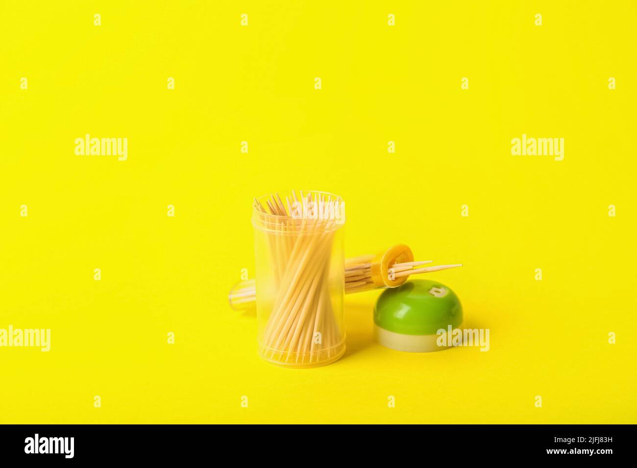 Holder with toothpicks on yellow background Stock Photo - Alamy