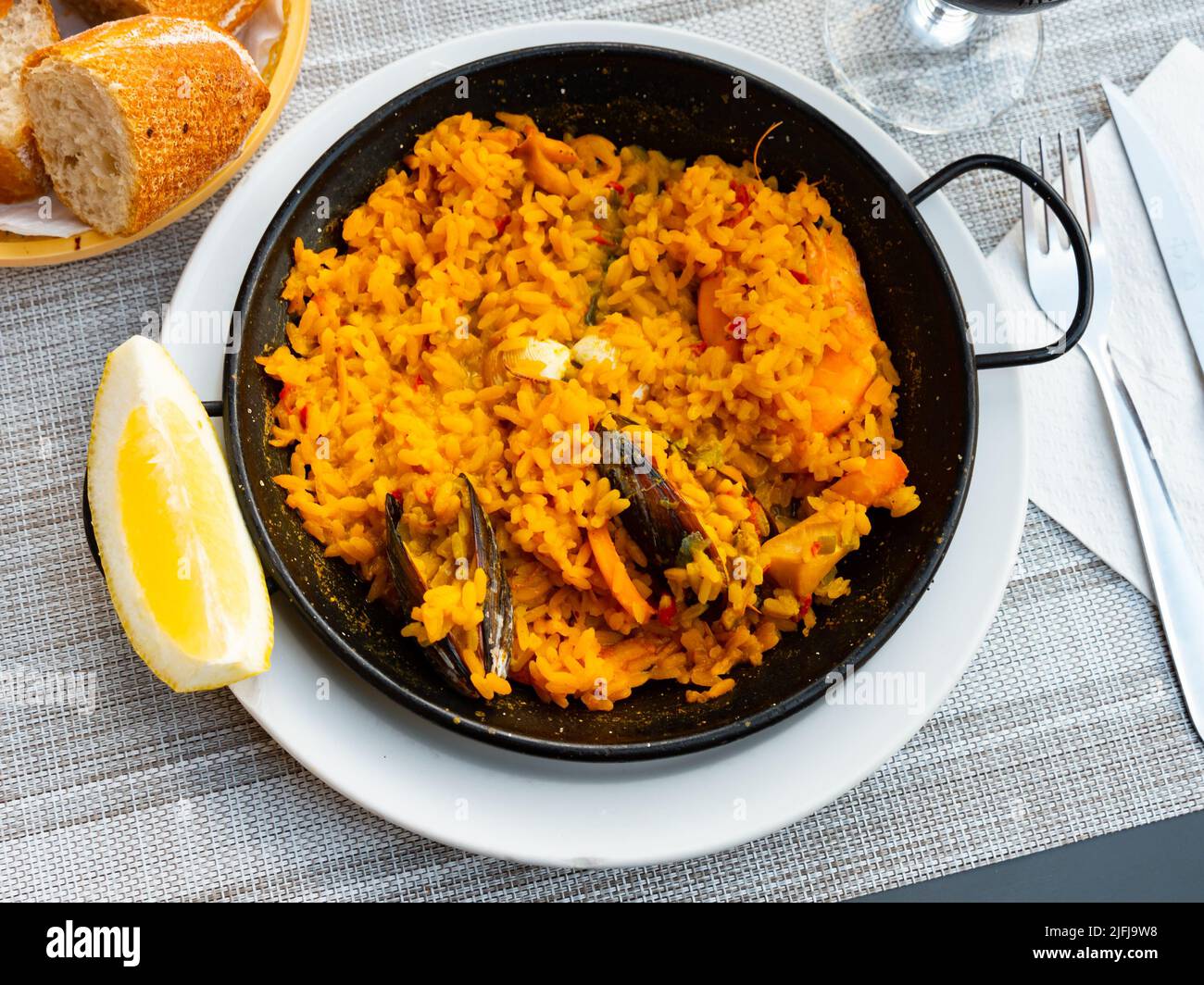 Traditional dish of Spanish cuisine is paella with seafood Stock Photo ...