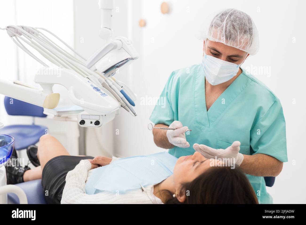 Dentist man examining a latin female patient teeth Stock Photo - Alamy