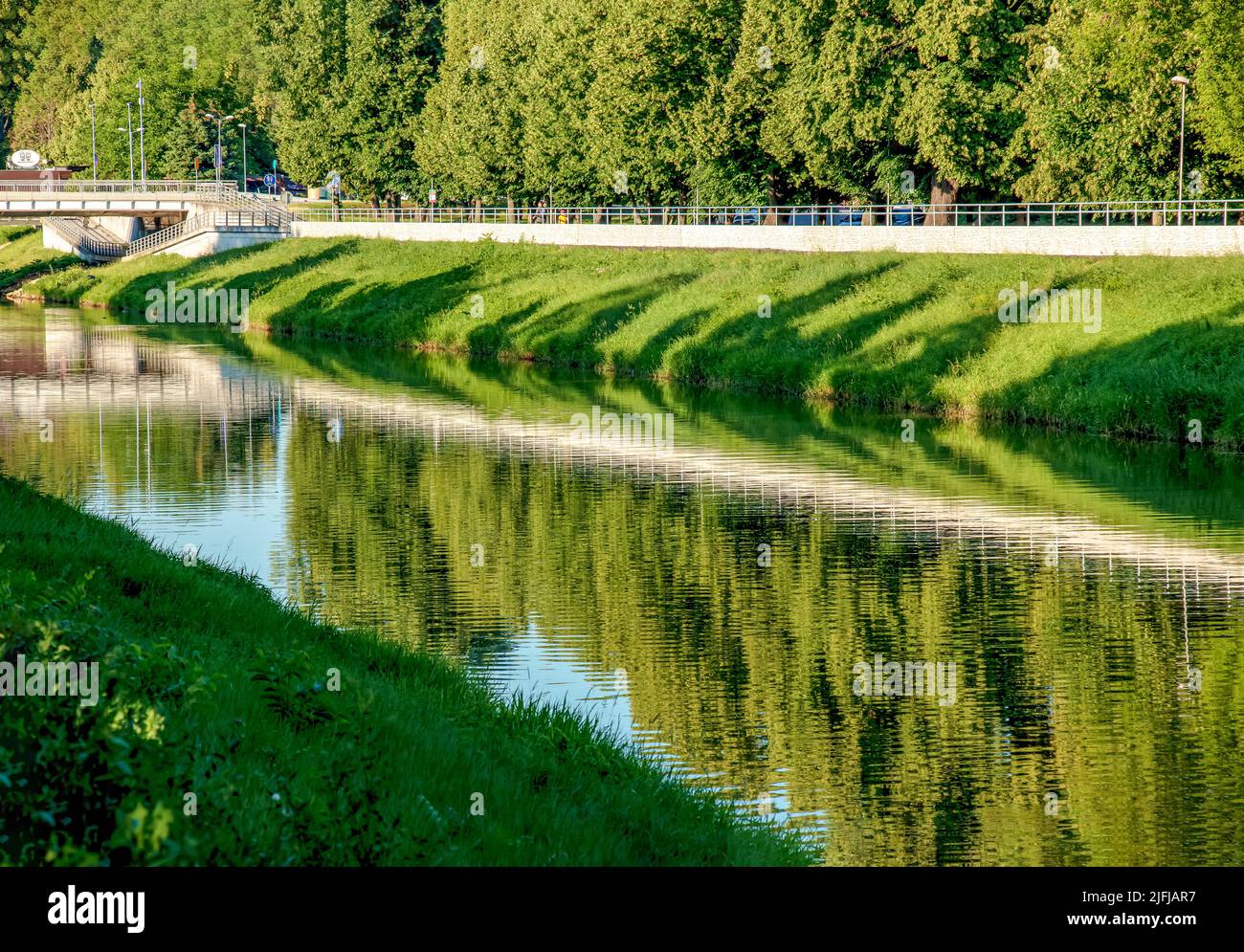The river flows through the city. On the calm surface of the river ...