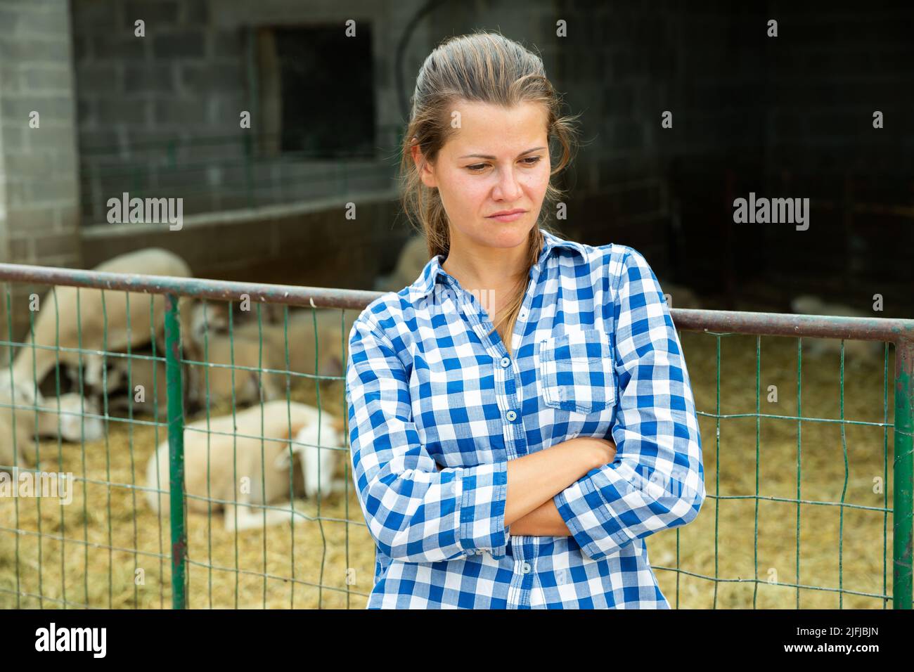 Tired farm worker stands near the corral Stock Photo - Alamy