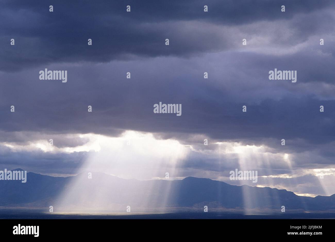 Sunbeams shining through storm clouds Stock Photo - Alamy