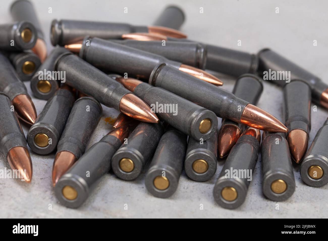 kalashnikov ak gun 7,62 mm bullets on grey concrete surface background ...