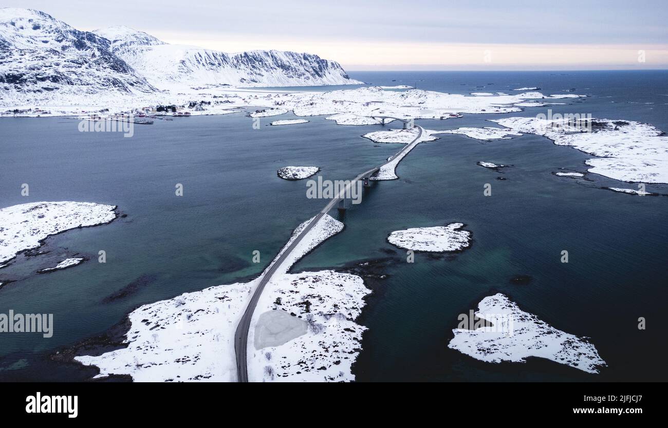An aerial view of the fjord, road, bridge, and mountains in Lofoten ...