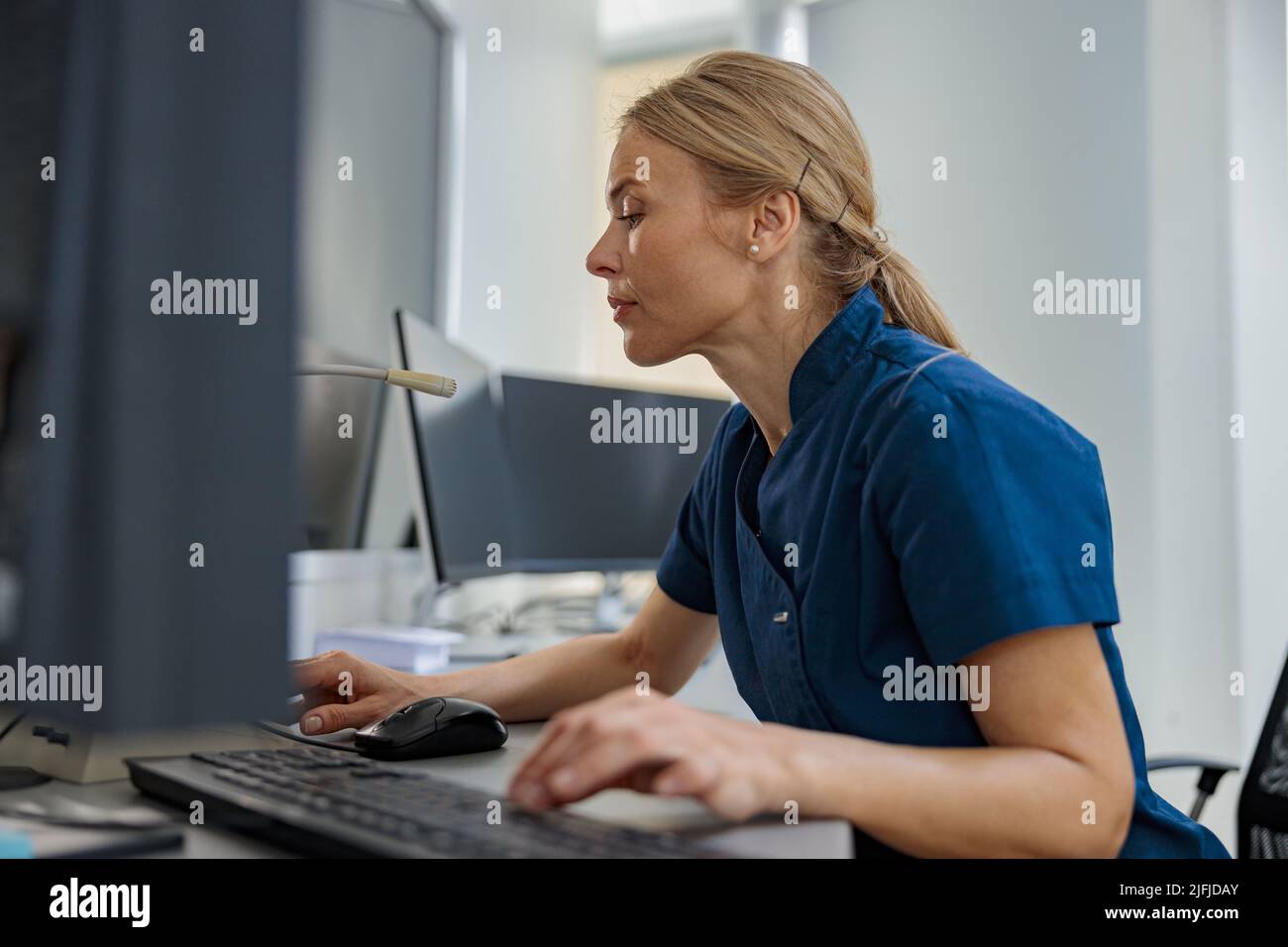 Nurse on Duty working on computer at the Reception Desk in modern ...