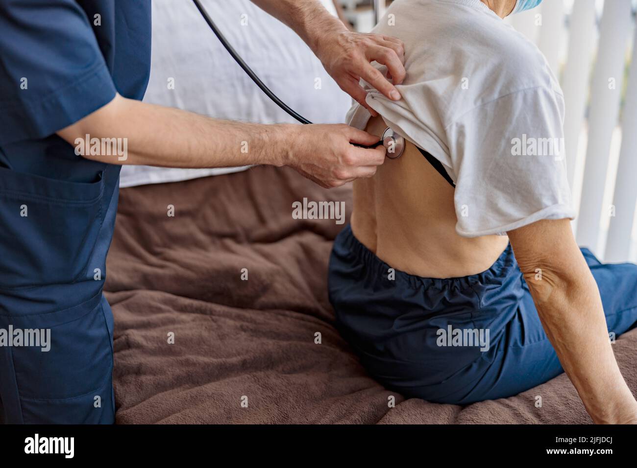 Close up of doctor listening to old woman's patient breathing, using ...