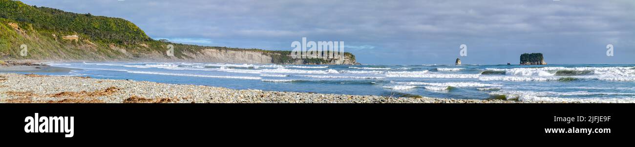 Wide panorama of stony Rapahoe beach and view to horizon with headland ...