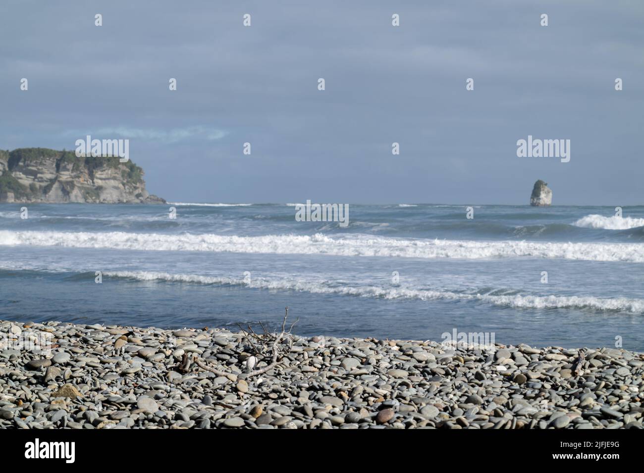 Focus on foreground with defocused background stony Rapahoe beach and ...