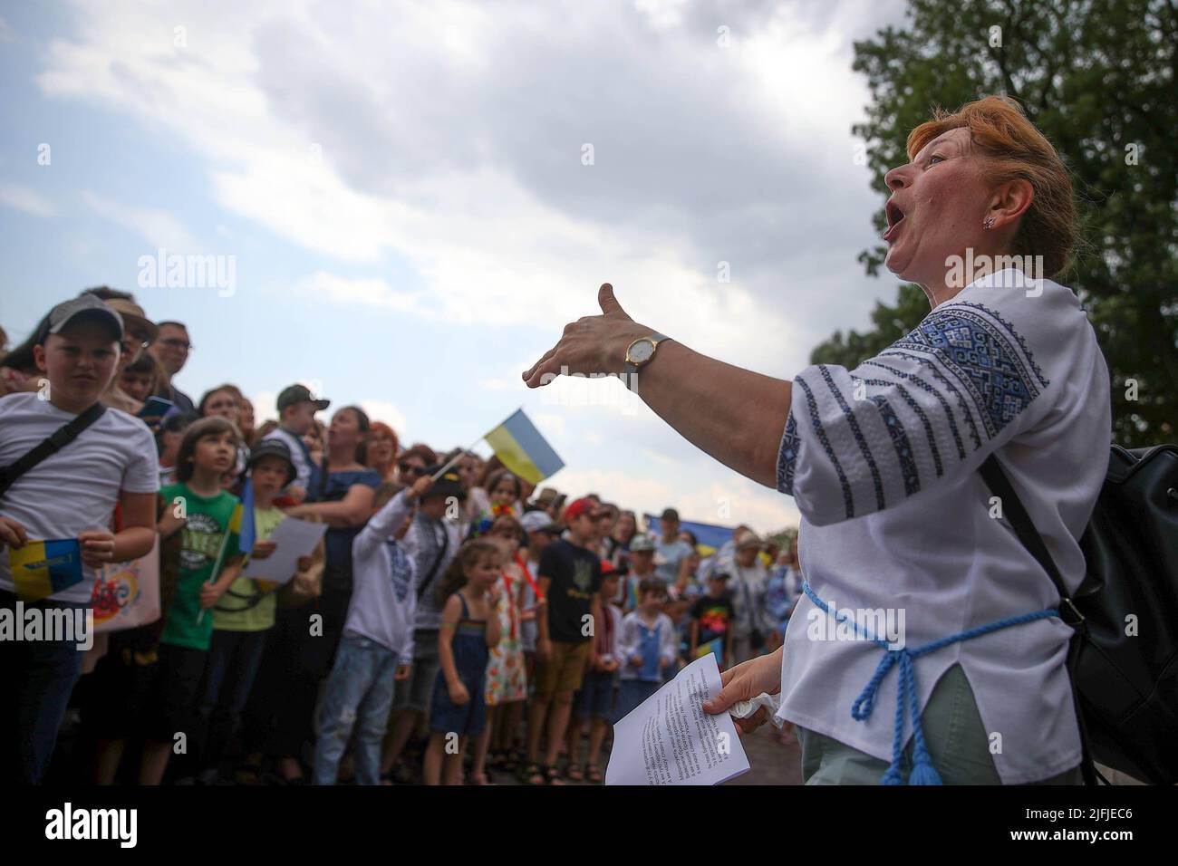 A woman conducts the group singing during the record breaking attempt ...