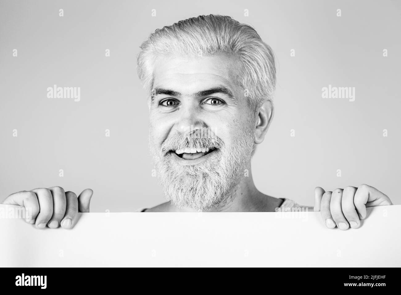 Smiling man holding card, man with banner, isolated yellow background ...