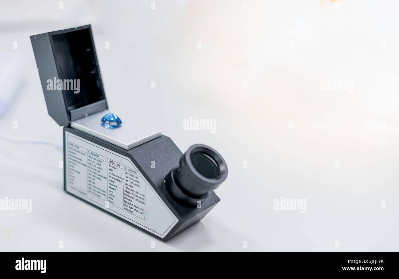 The blue precious stone and put on the refractometer for confirm the ...
