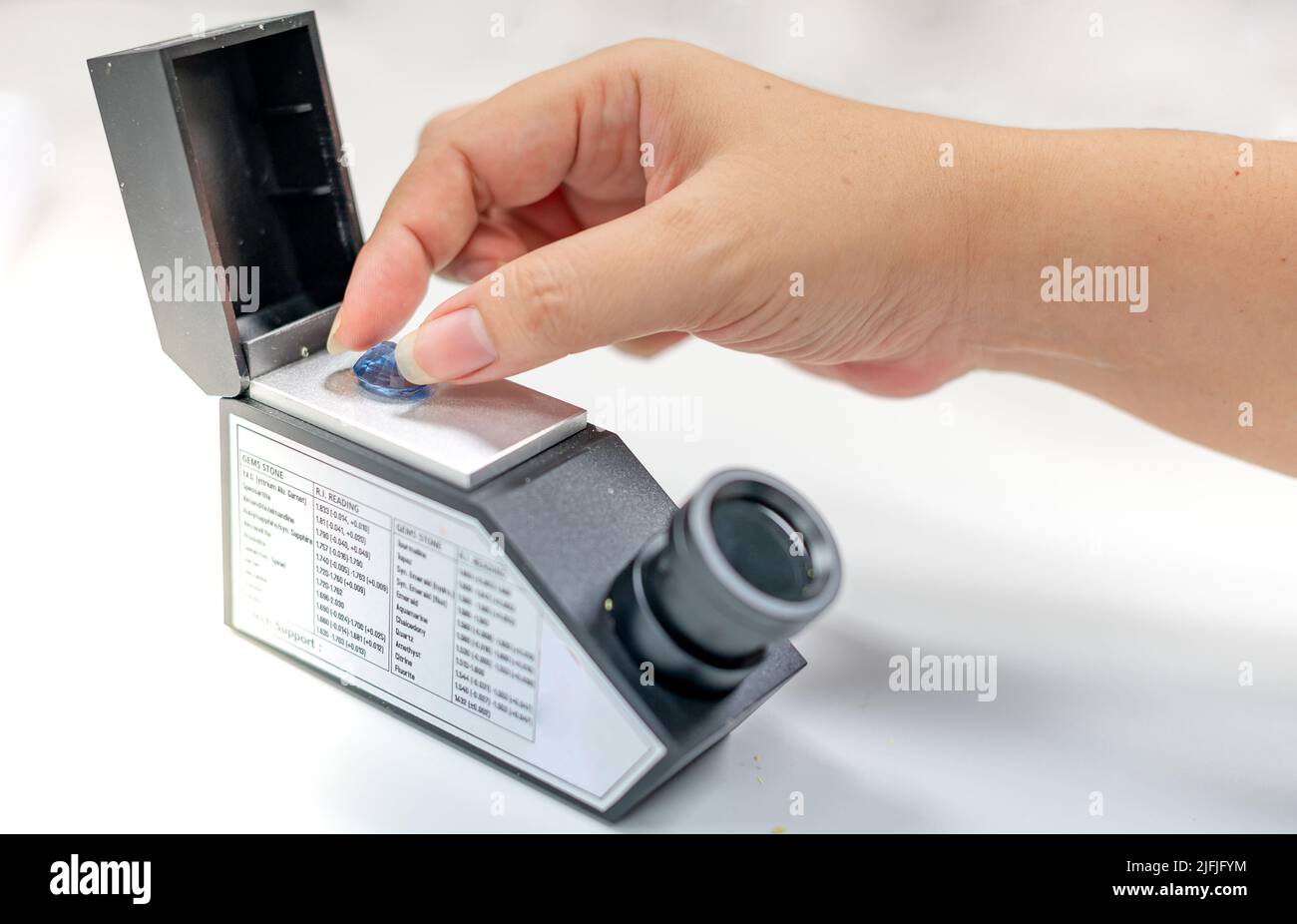 Female hand holding the blue precious stone and put on the ...