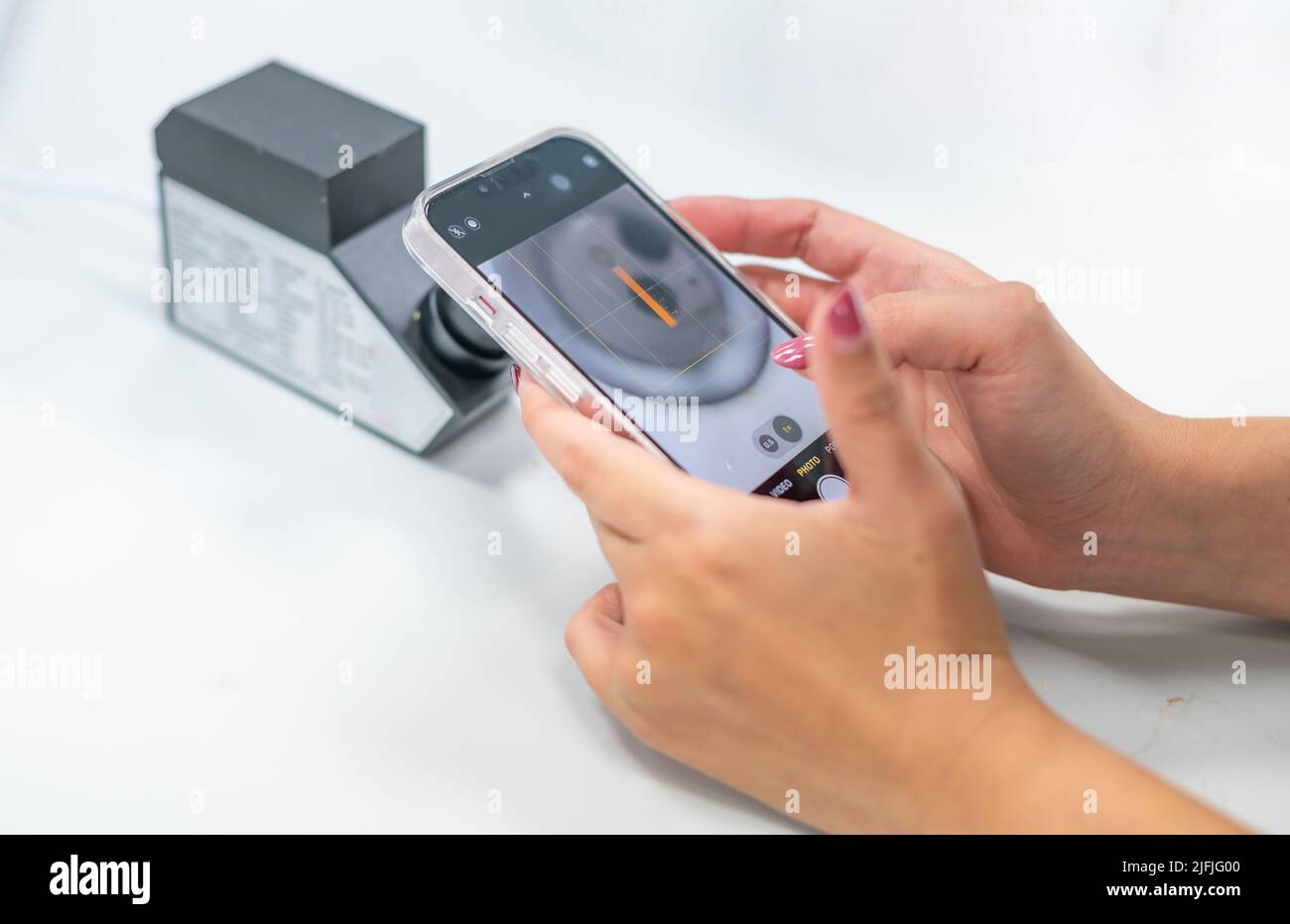 Female hand holding smartphone for taking a photo with the RI of a ...