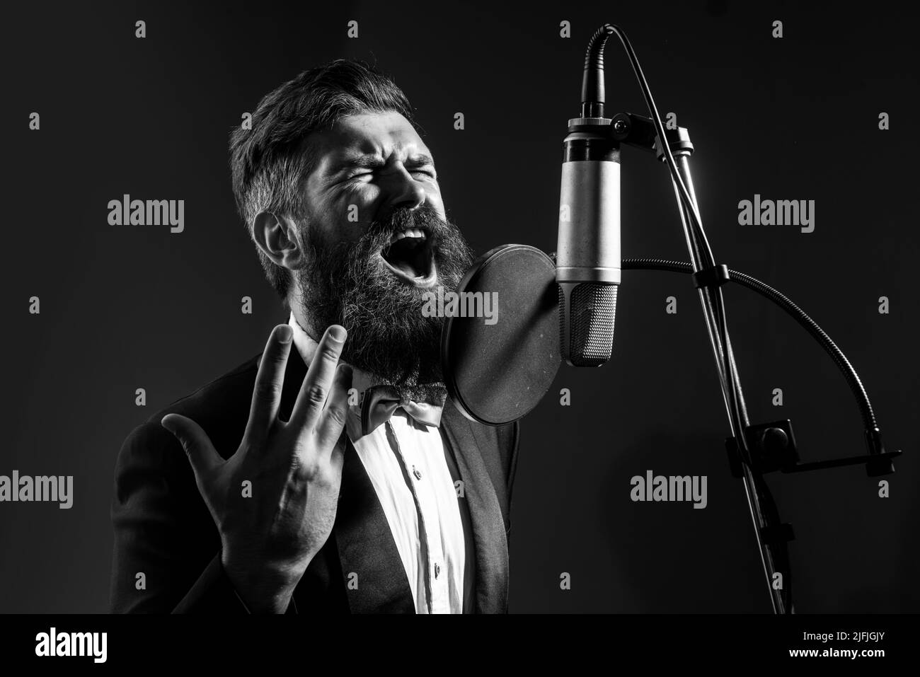 Singer is performing a song with a microphone while recording in a ...