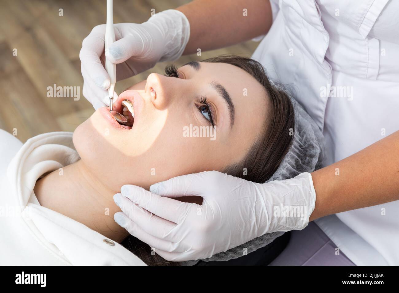 Dentist examining patient teeth with mirror in dentist clinic Stock ...