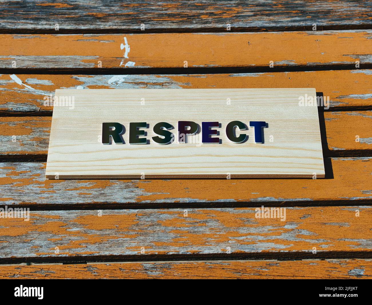 The word Respect in rainbow colored lettering on an old rustic orange ...