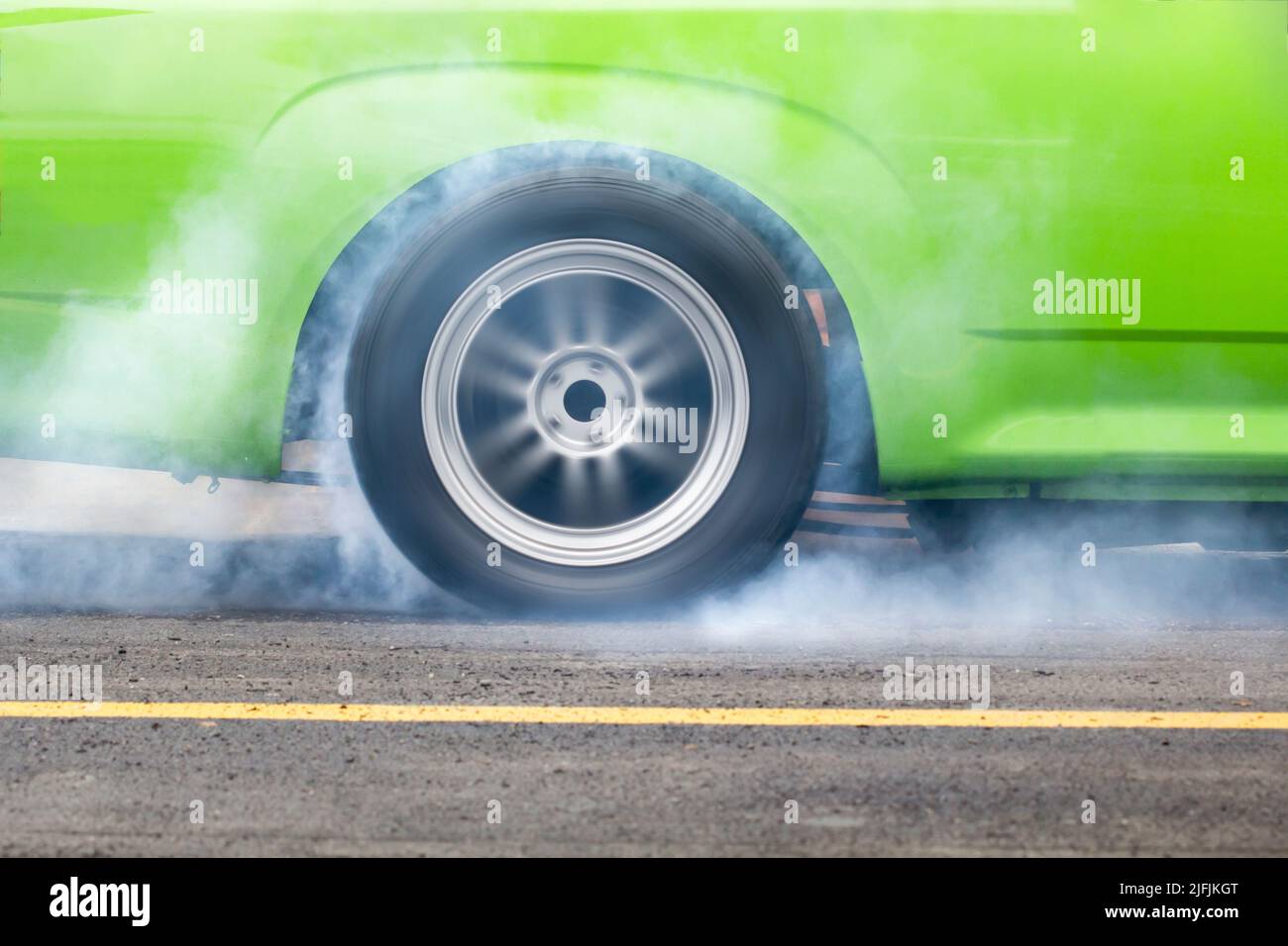 race car burns rubber off its tires in preparation for the race Stock ...