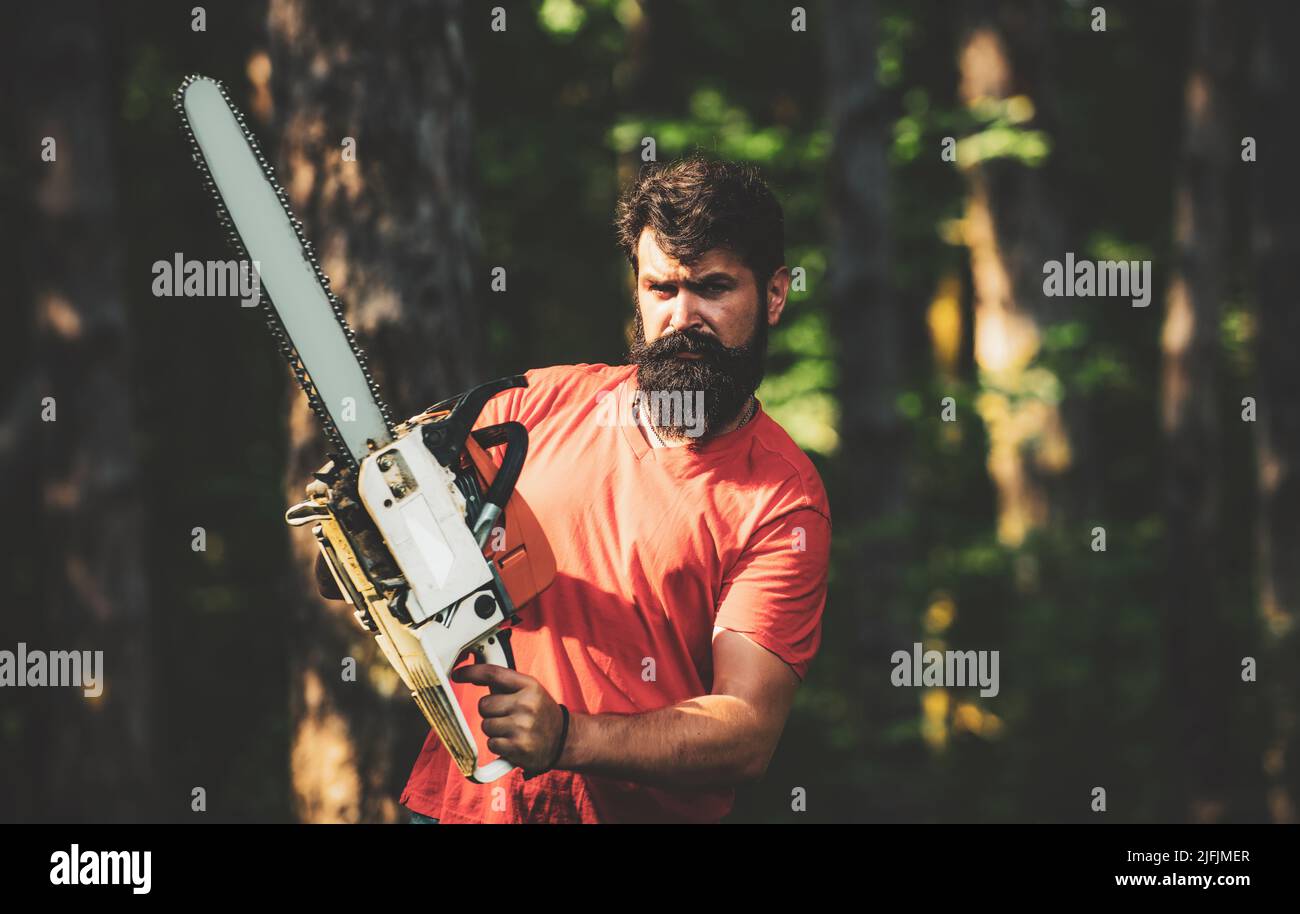 Handsome young man with axe near forest. Deforestation. Lumberjack in ...