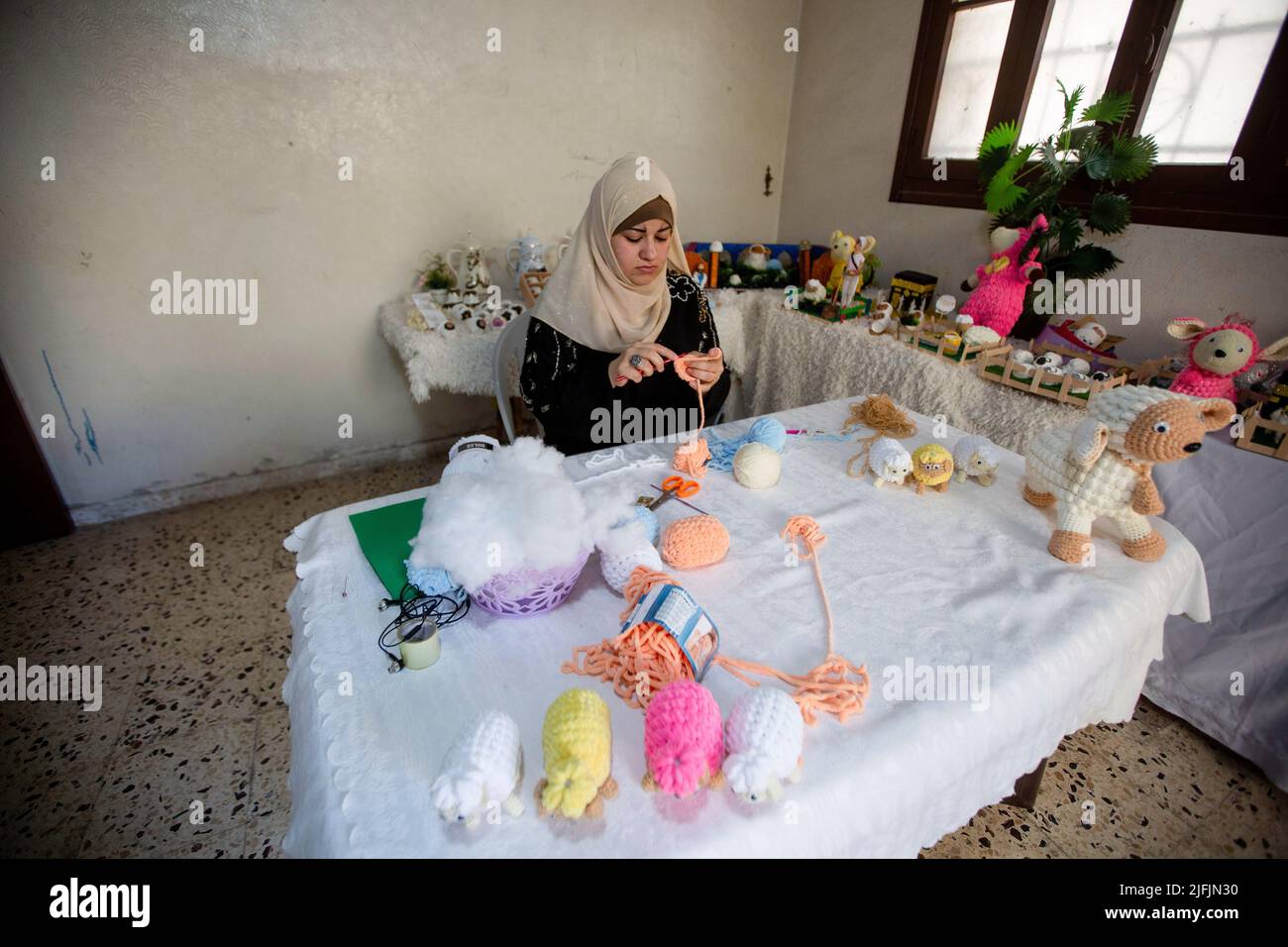 Gaza, Palestine. 02nd July, 2022. A Palestinian woman knits a doll in a ...