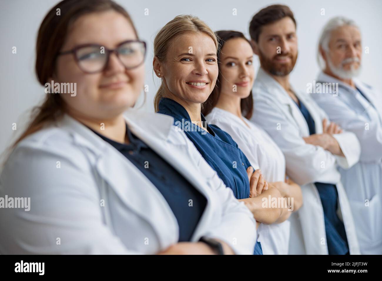Group of doctors standing in a line keeping arms crossed and looking ...