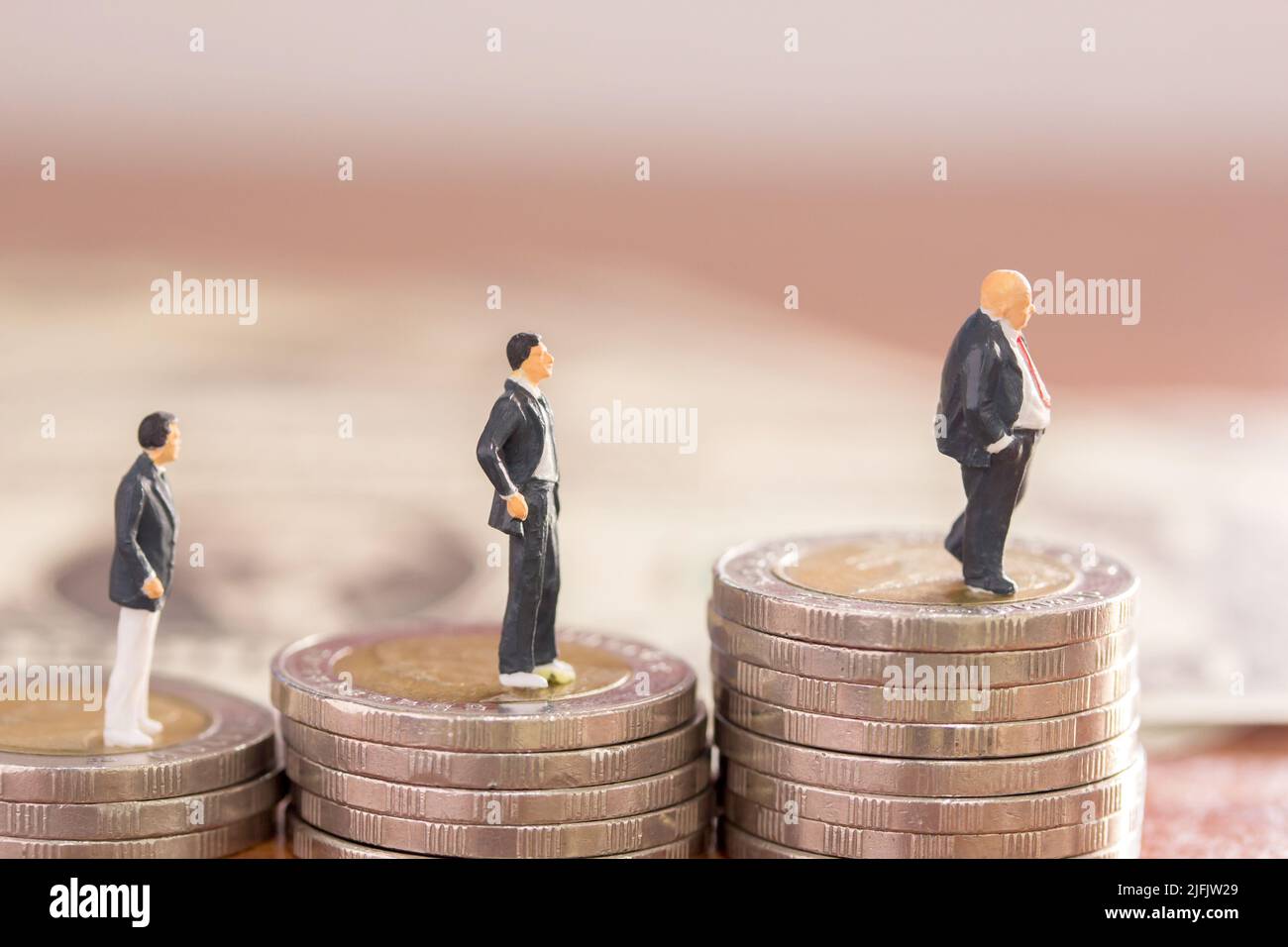 Miniature people : Businessman figures standing on the coin with ...