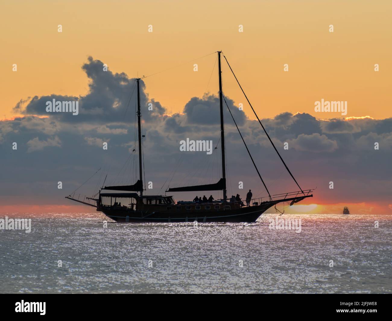 View of Twin-masted classic sailing boat among cloudy sunset Stock ...