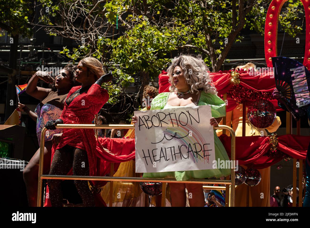 Person participating in the pride parade, holding a pro choice placard ...