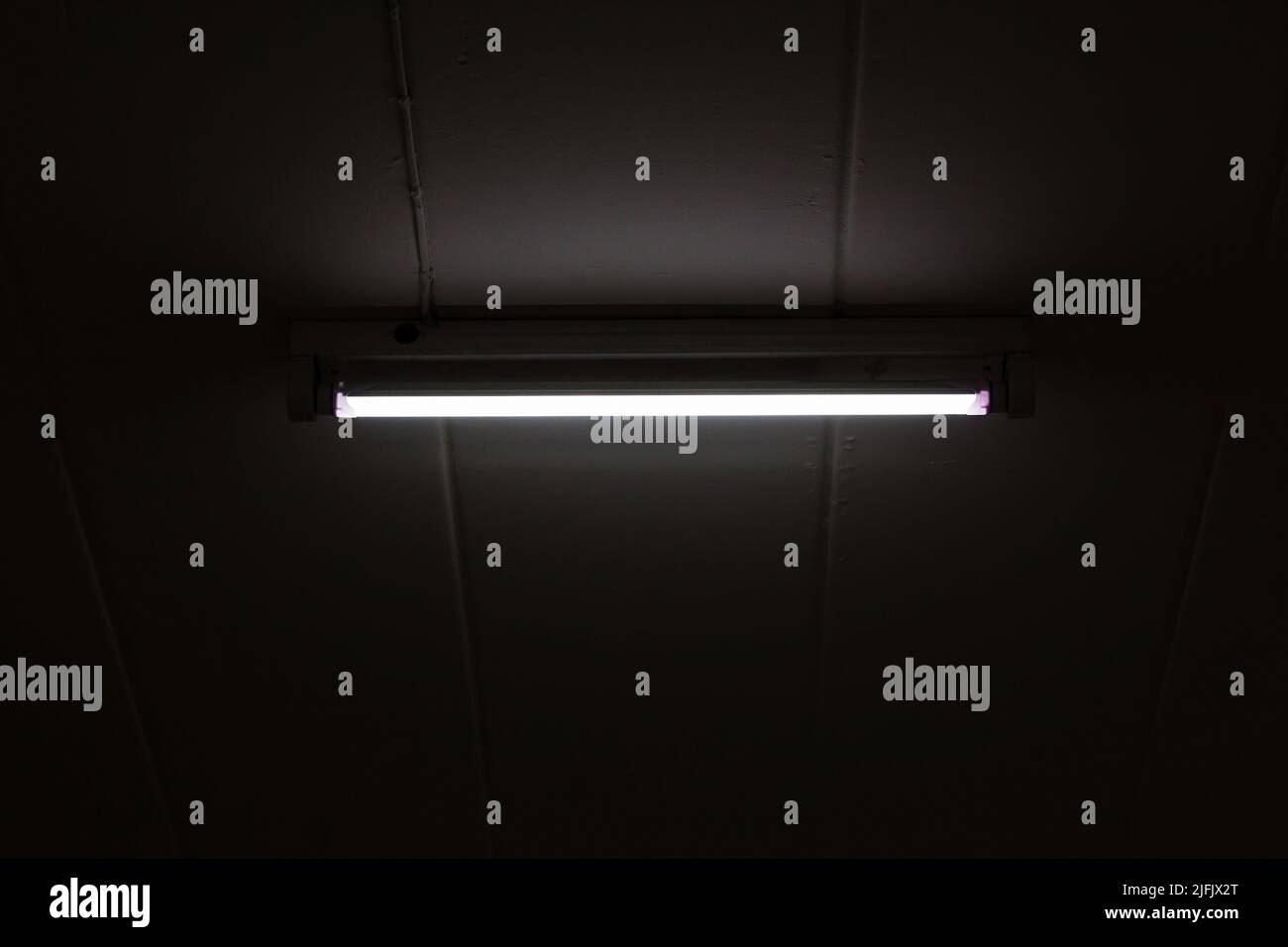 Detail of a fluorescent light tube mounted on a wall Stock Photo - Alamy