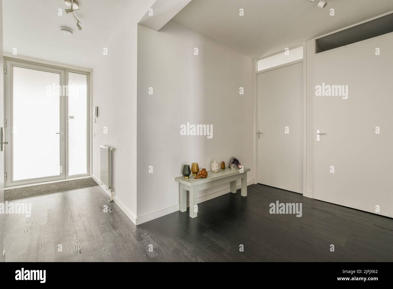 Spacious bright empty room with white walls, glass door and parquet ...