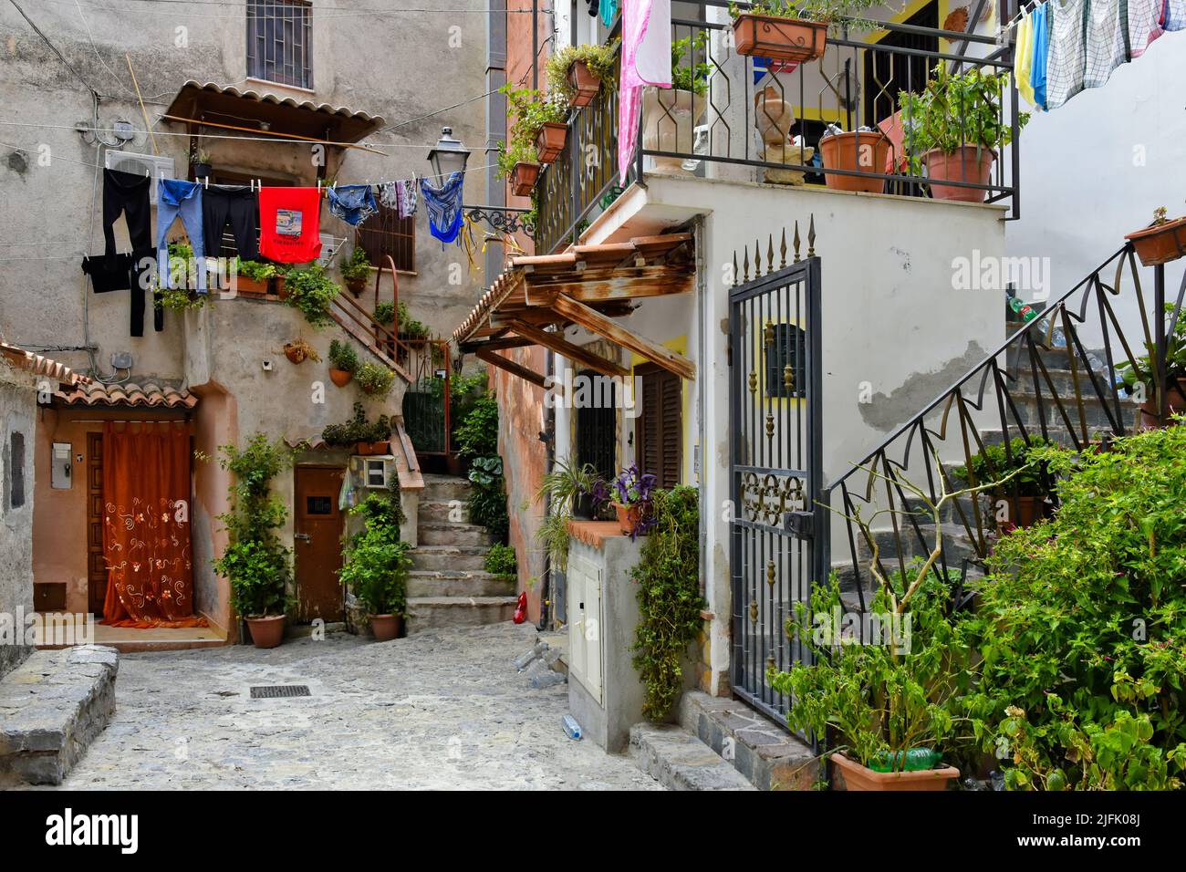 A beautiful shot of a narrow street between old houses in Scalea ...