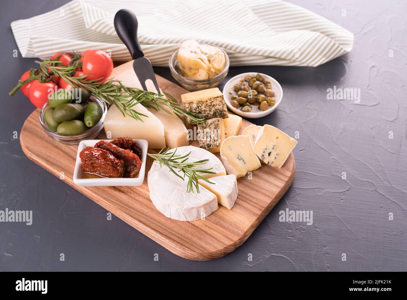Cheese plate with selection of cheeses served with olives, tomatoes and ...