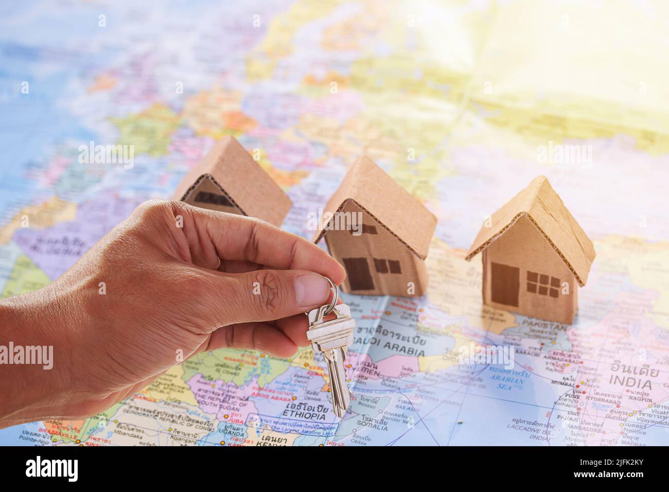 Selective focus - Human hand holding key of paper house toy or ...