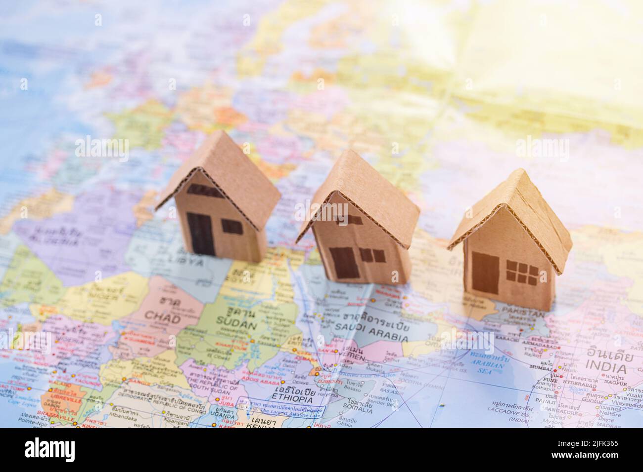 Selective focus of paper house toy or cardboard house on world map with ...