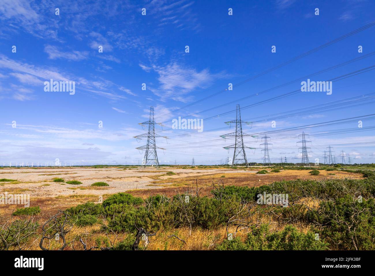 Electricity Pylons running over the barren landscape of Lydd ranges ...