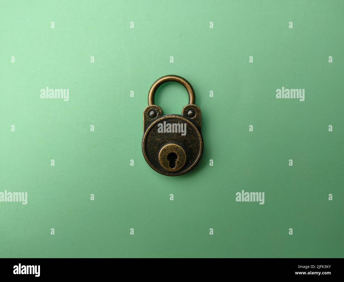 A bronze vintage padlock on soft green paper background Stock Photo - Alamy