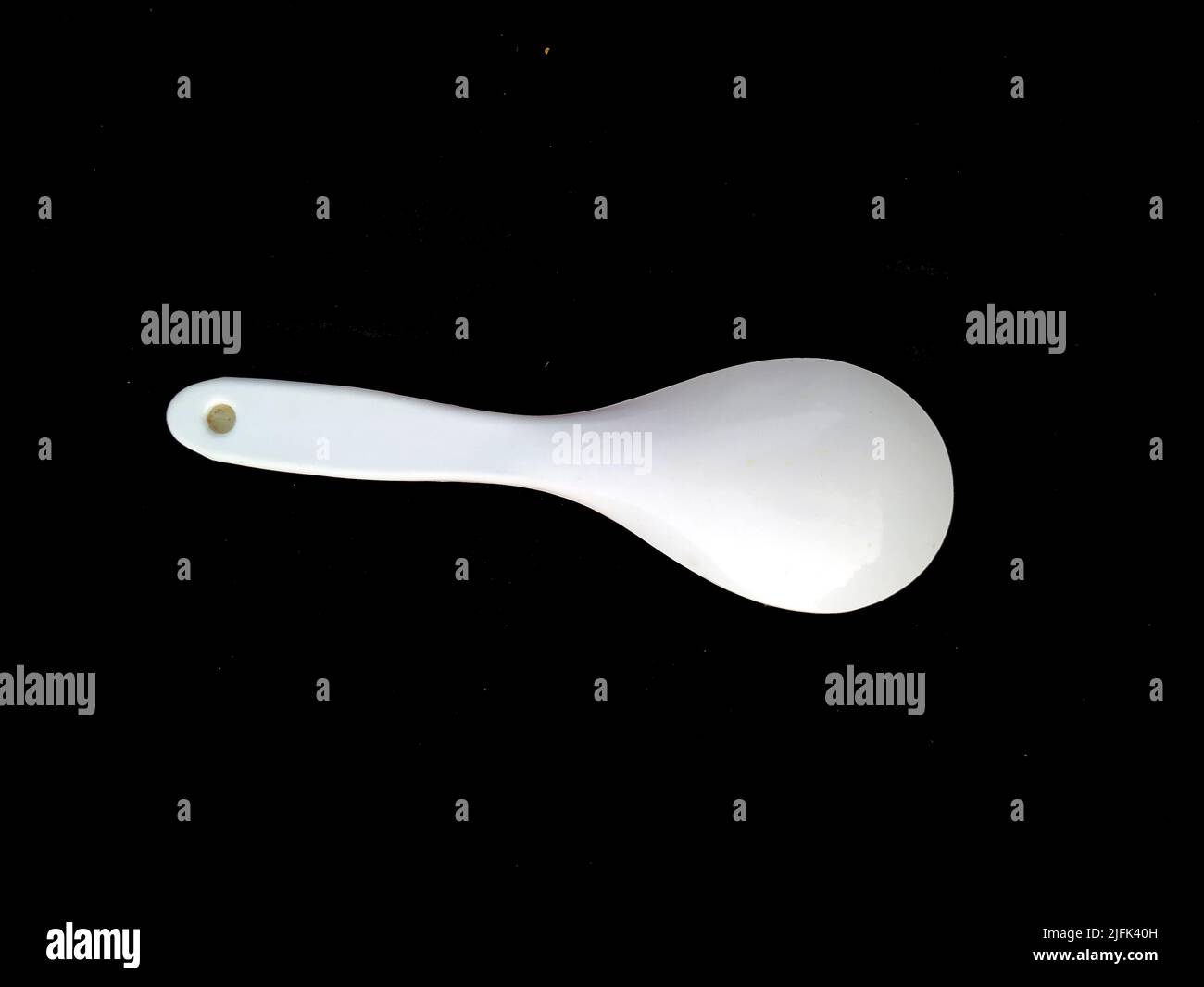 big plastic spoon isolated on black background Stock Photo - Alamy