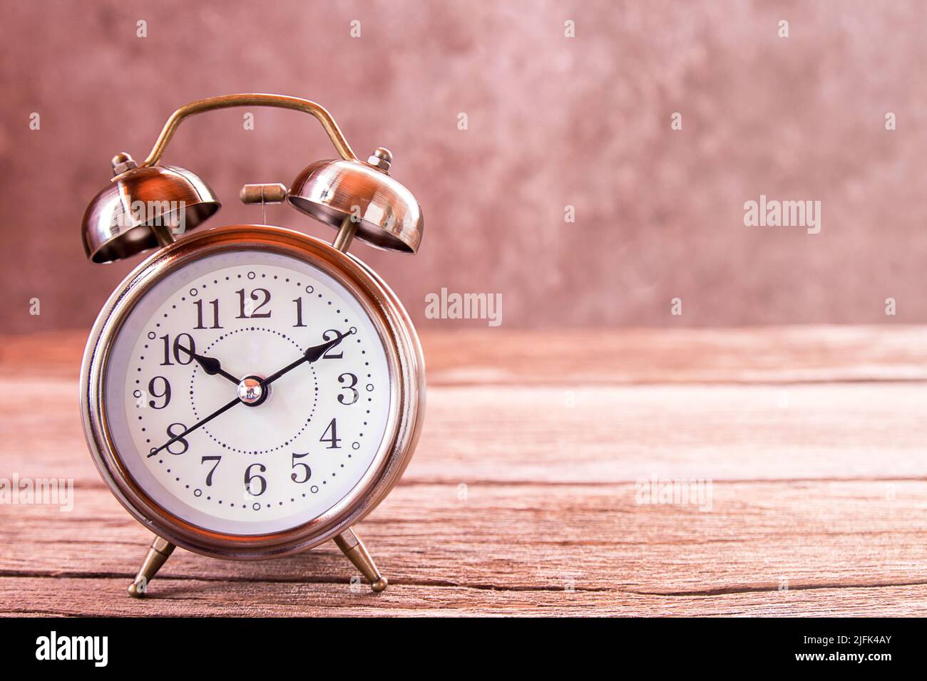 Retro alarm clock on a wooden table. Photo in retro color image style ...