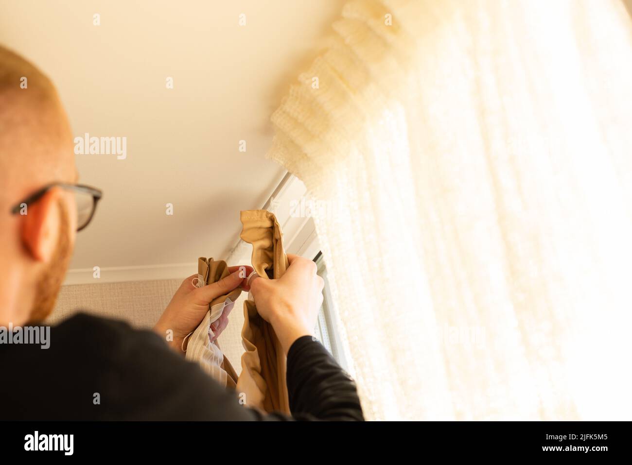 Man takes curtains off from windows. Housecleaning concept Stock Photo ...