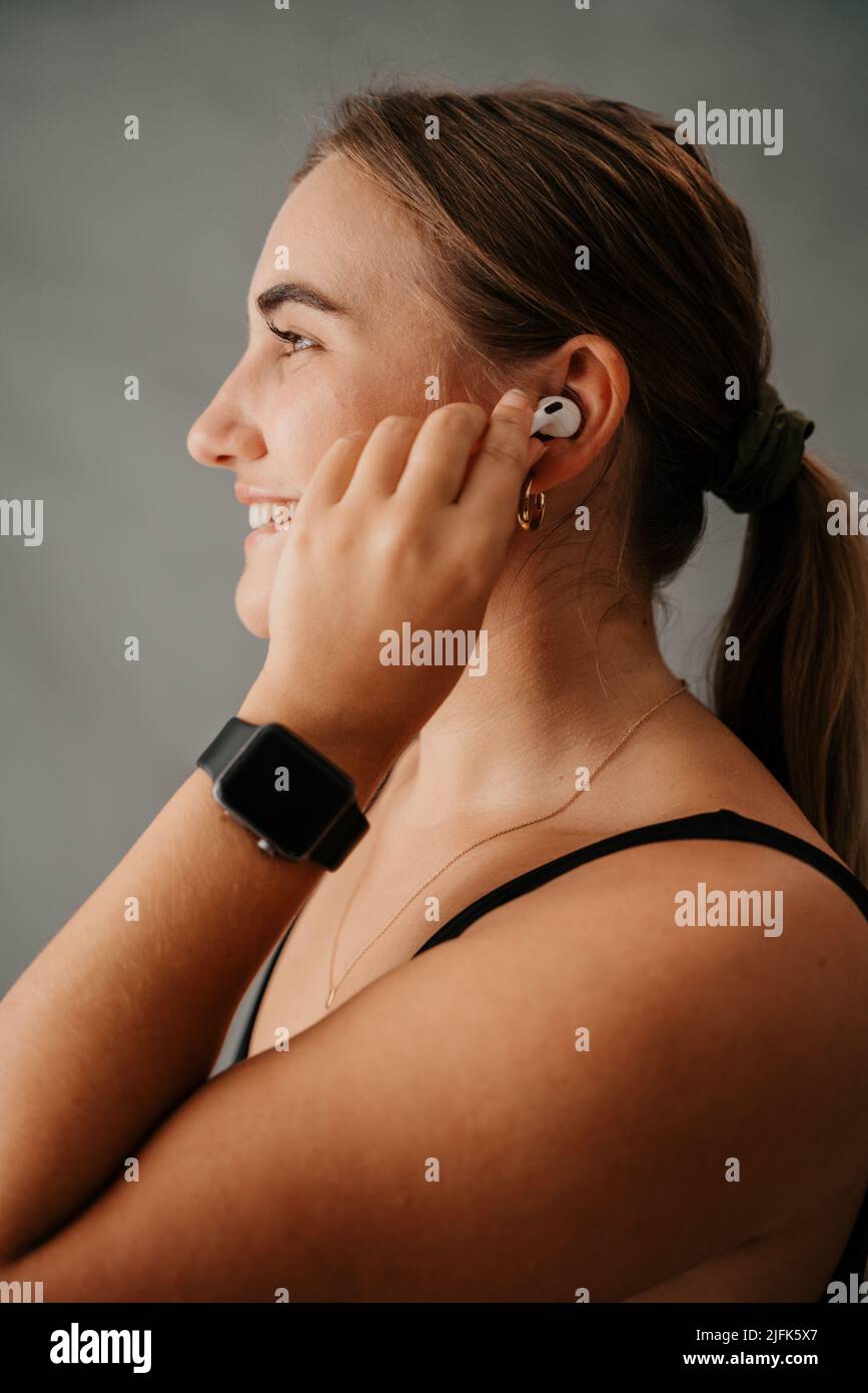 Close up head shot Caucasian female putting in her ear pods Stock Photo ...