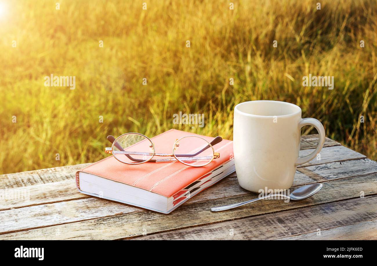 Cup of coffee and note book on wooden table background with morning ...