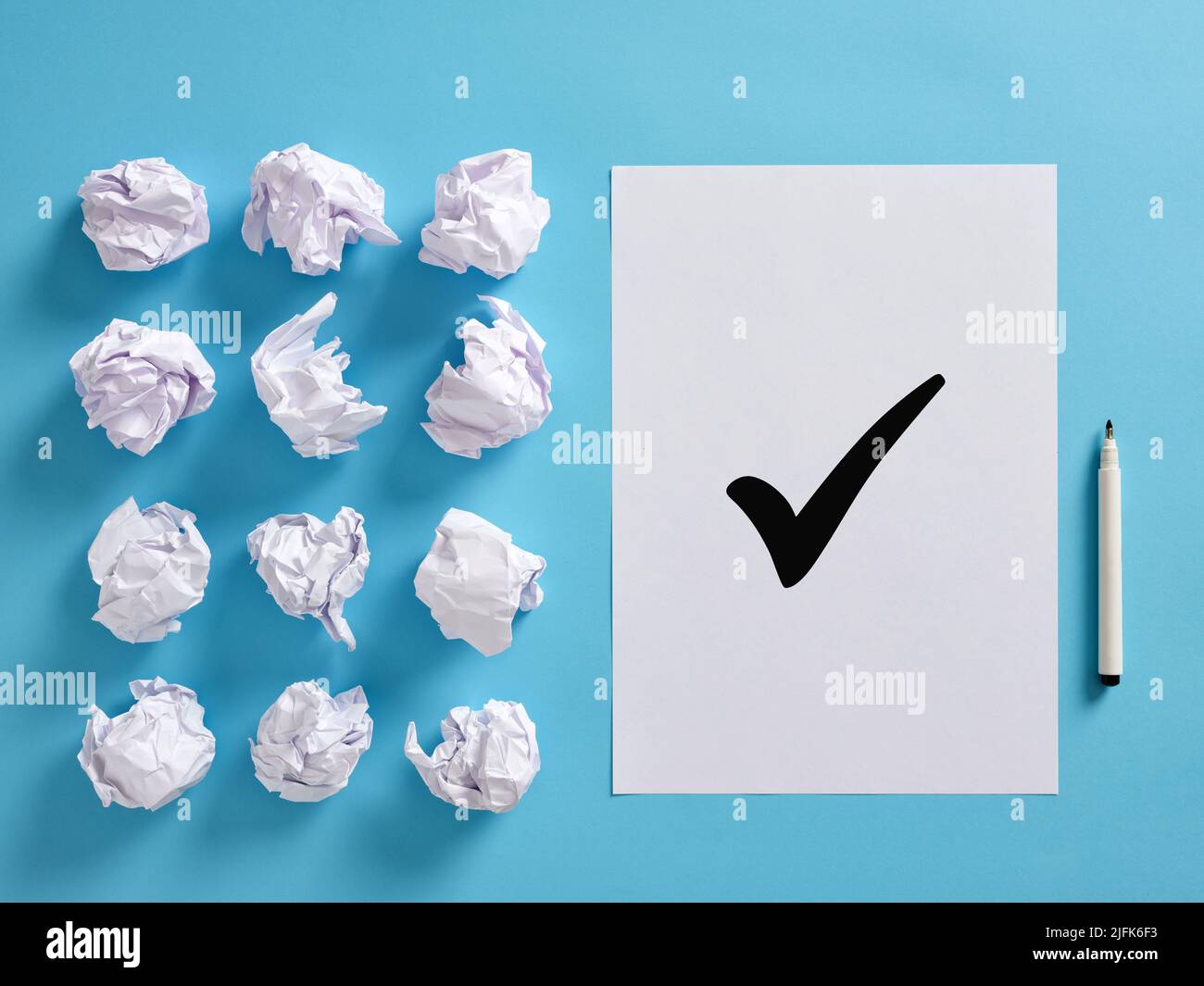 Checkmark or tick icon on a paper sheet with crumpled paper balls and a ...