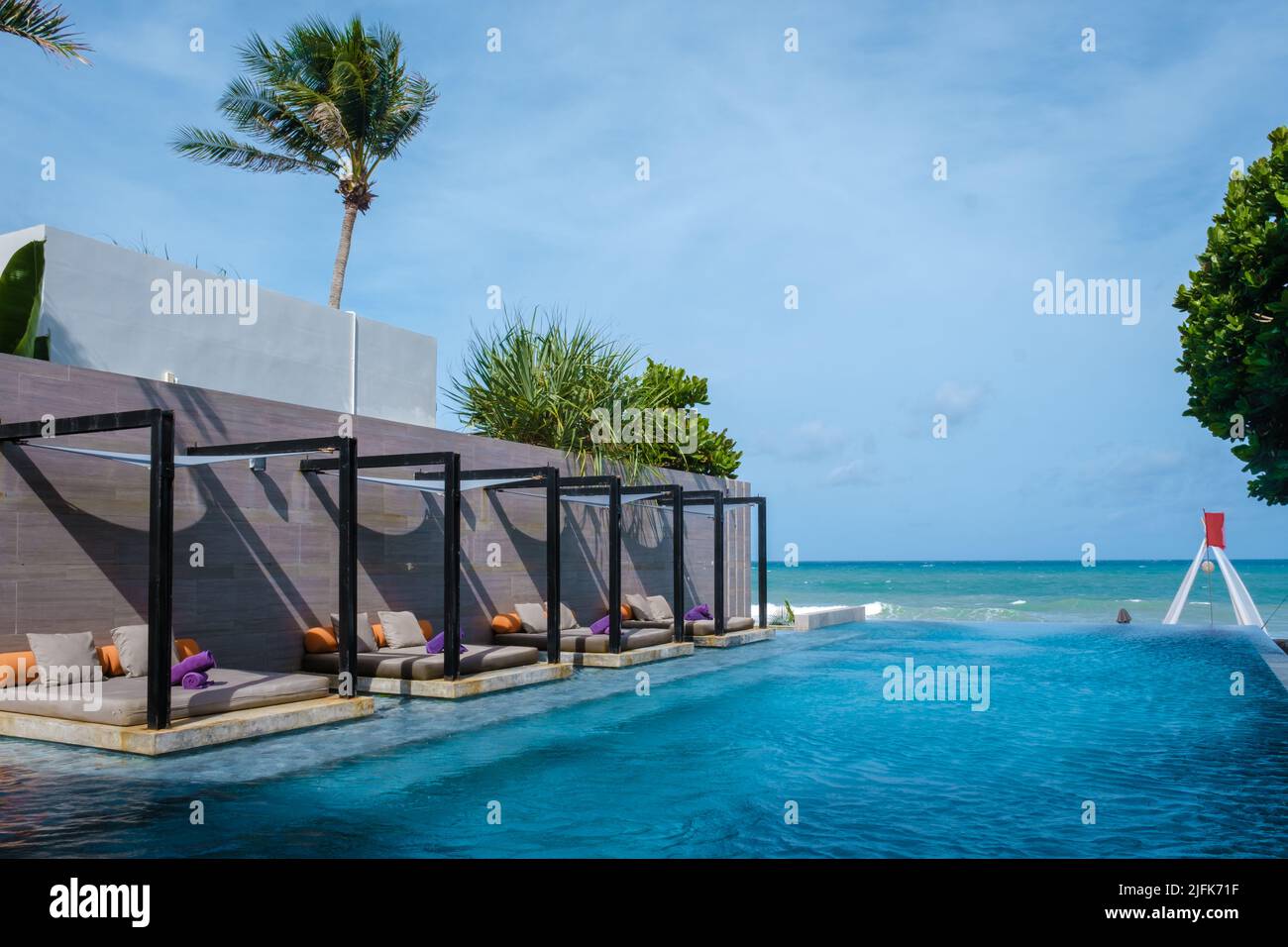 Modern Infinity pool at the beach. luxury infinity pool with beach beds ...